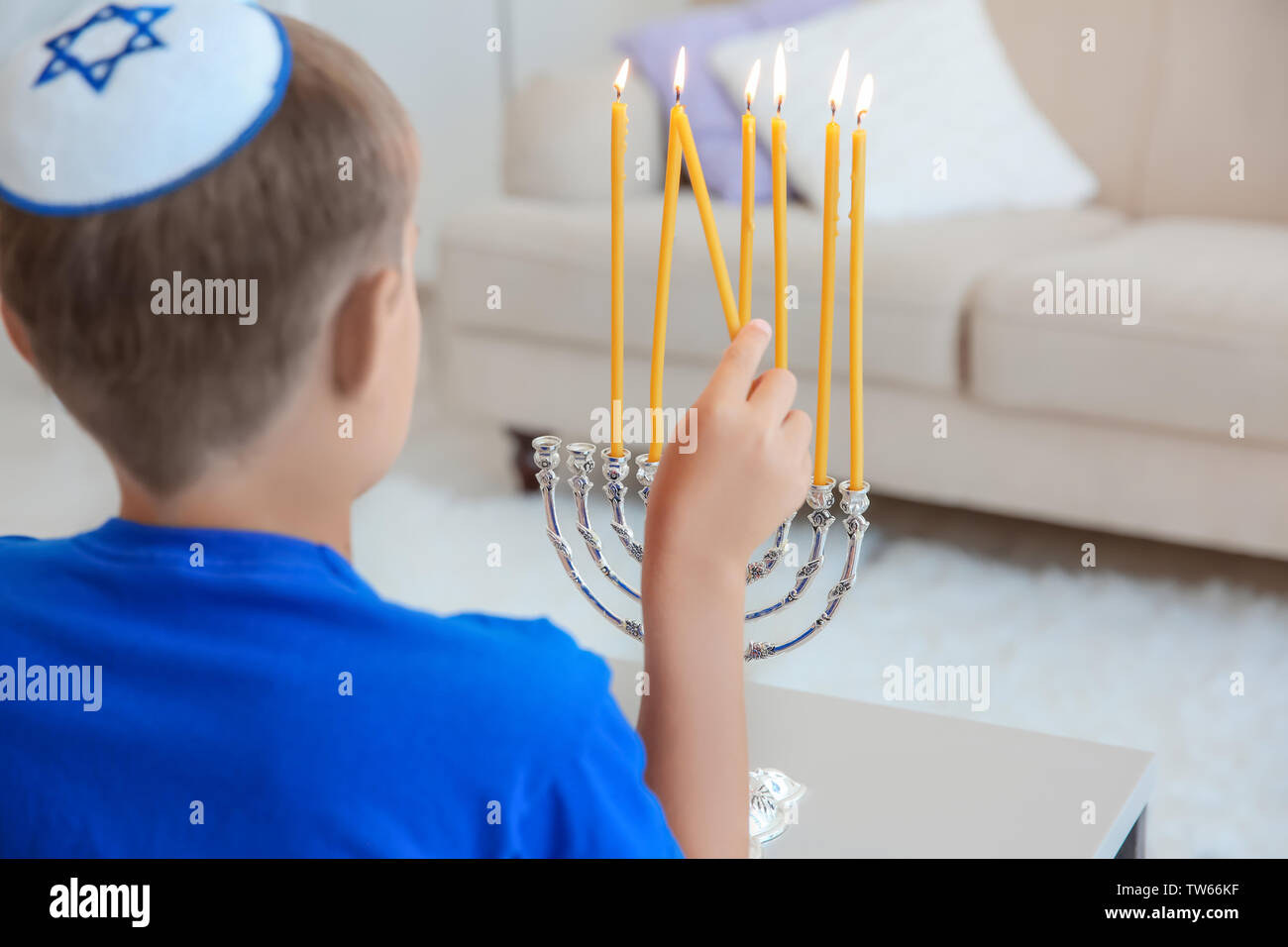 Jewish boy lightning menorah at home Stock Photo - Alamy