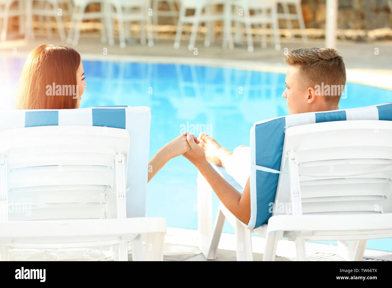Couple sitting near swimming pool hi-res stock photography and images ...