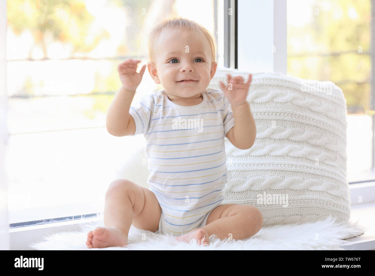 Cute little baby sitting on window sill at home Stock Photo - Alamy