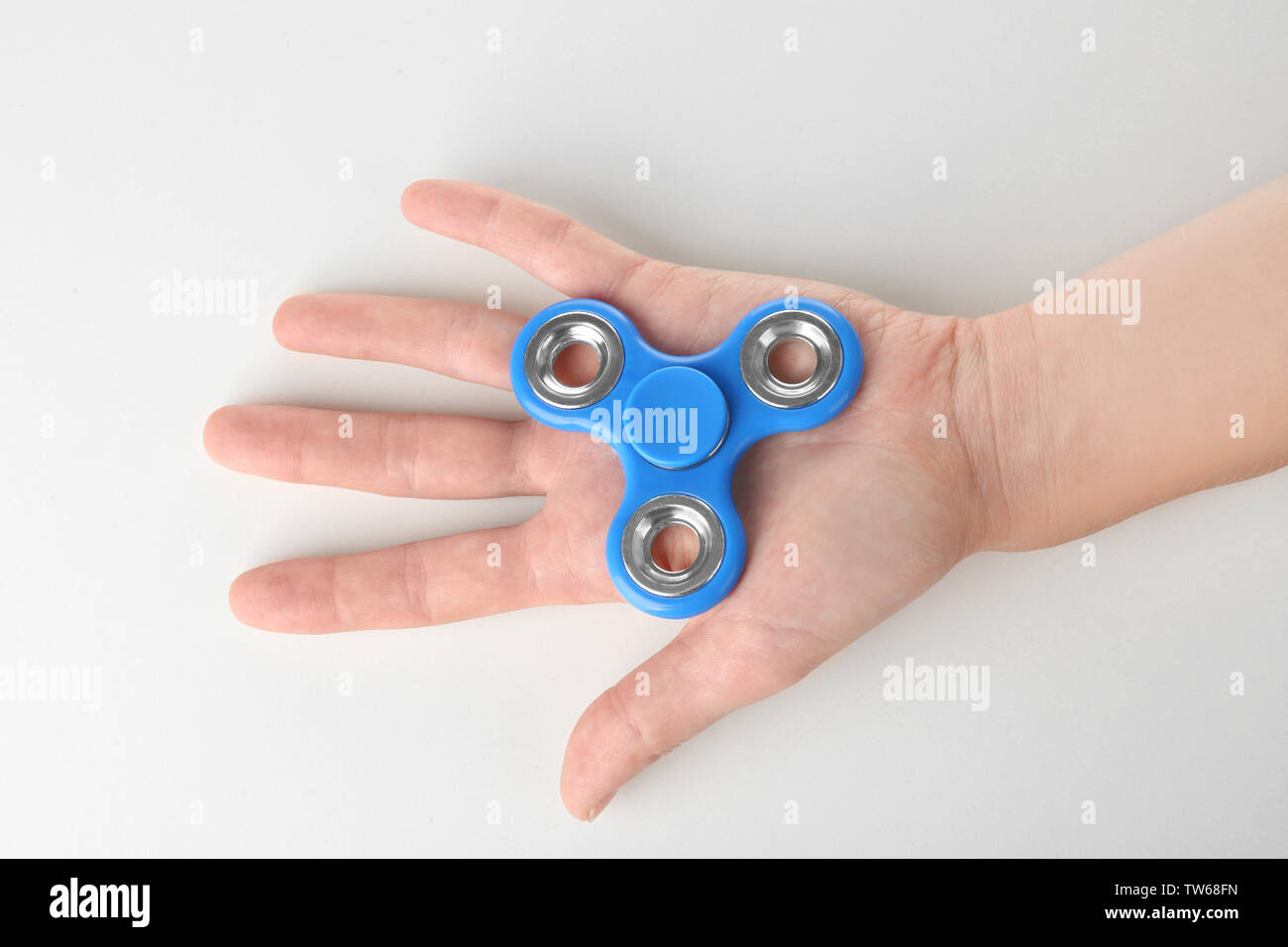 Man holding modern spinner on white background Stock Photo - Alamy