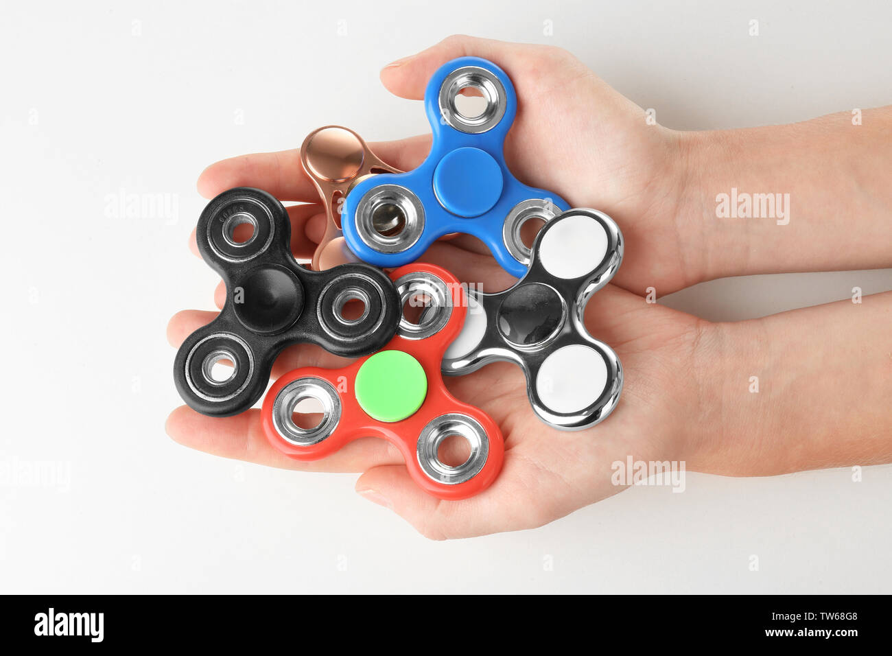 Man holding modern spinners on white background Stock Photo - Alamy