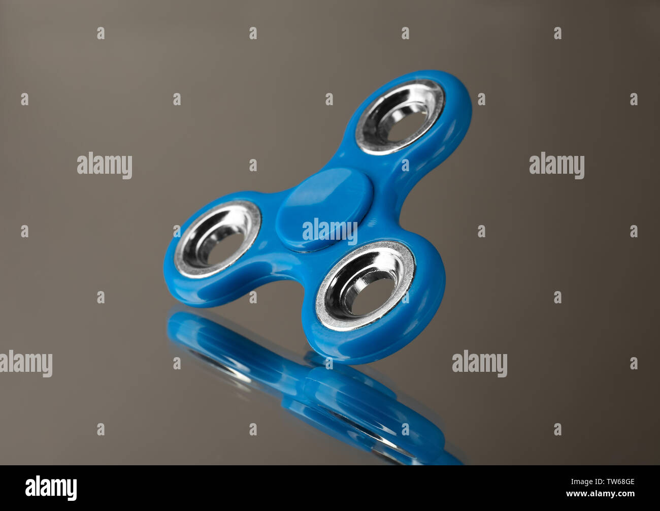 Modern spinner on mirror background Stock Photo - Alamy