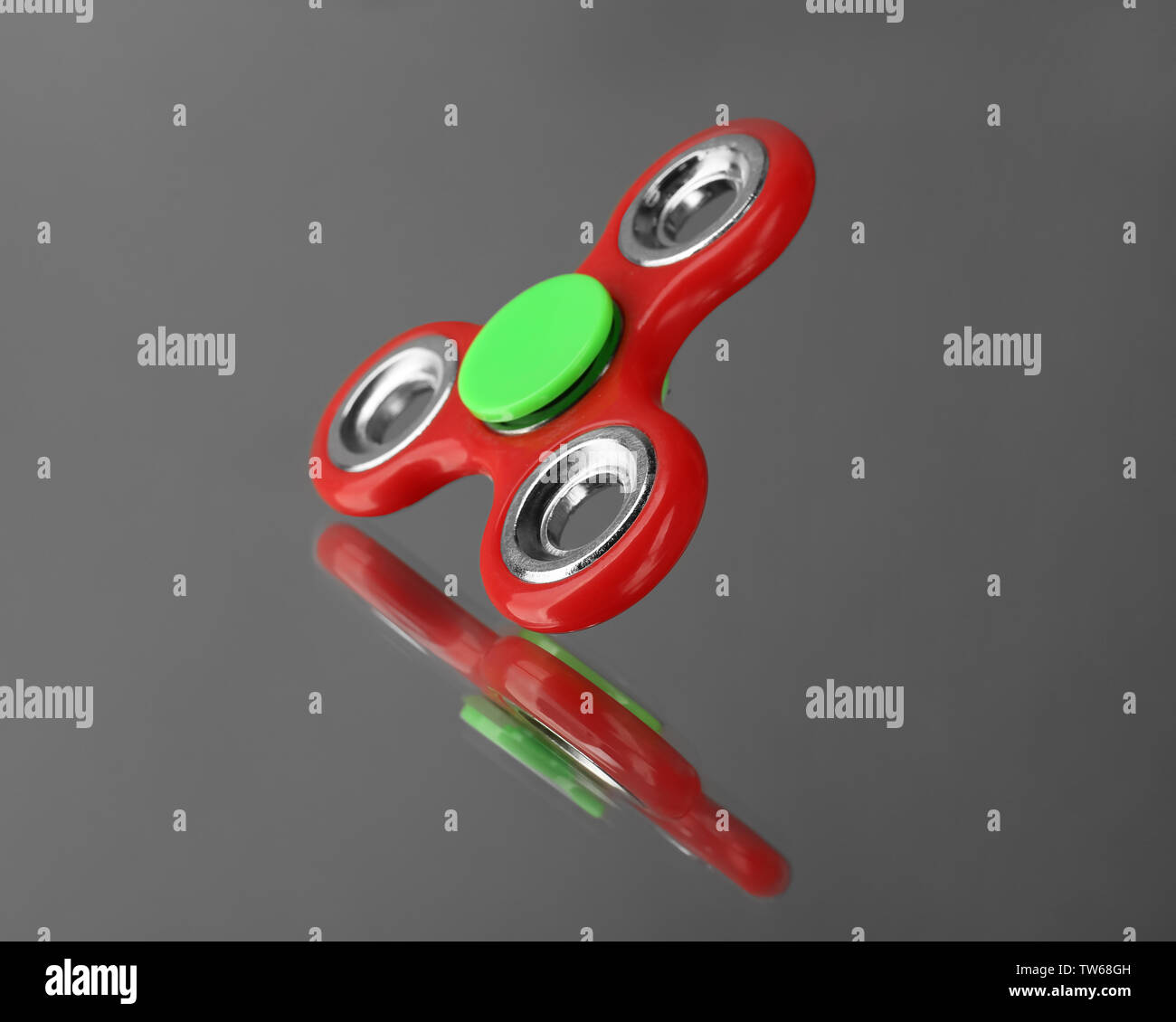 Modern spinner on mirror background Stock Photo - Alamy