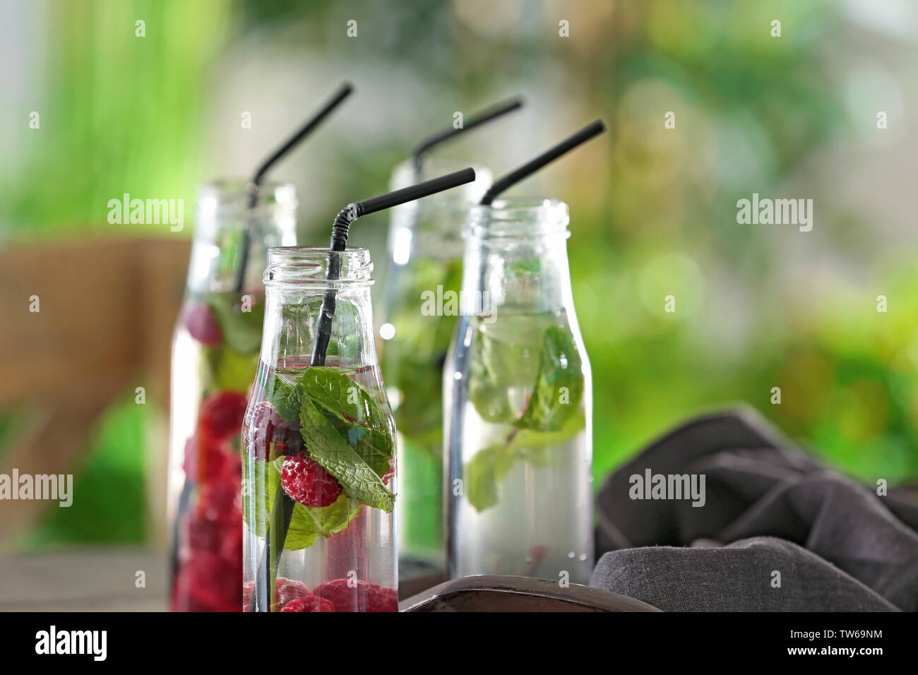 Bottles of infused water with berries on blurred background Stock Photo ...