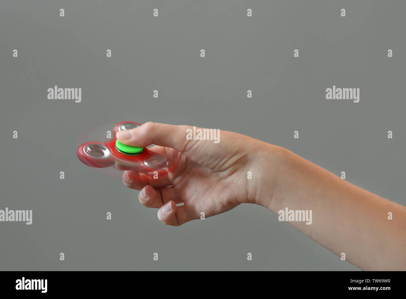 Woman rolling modern spinner on grey background Stock Photo - Alamy