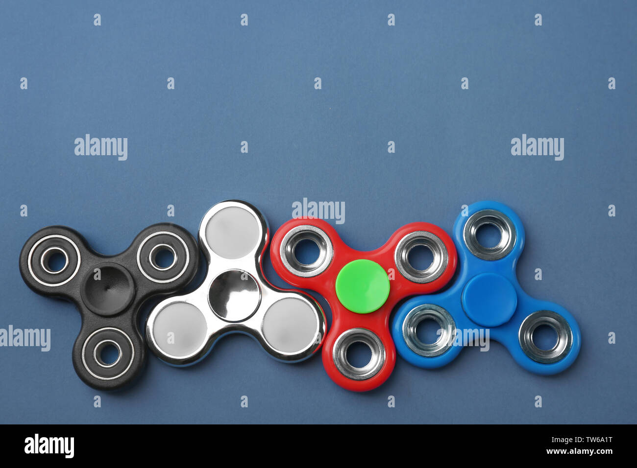 Different modern spinners on color background, top view Stock Photo - Alamy