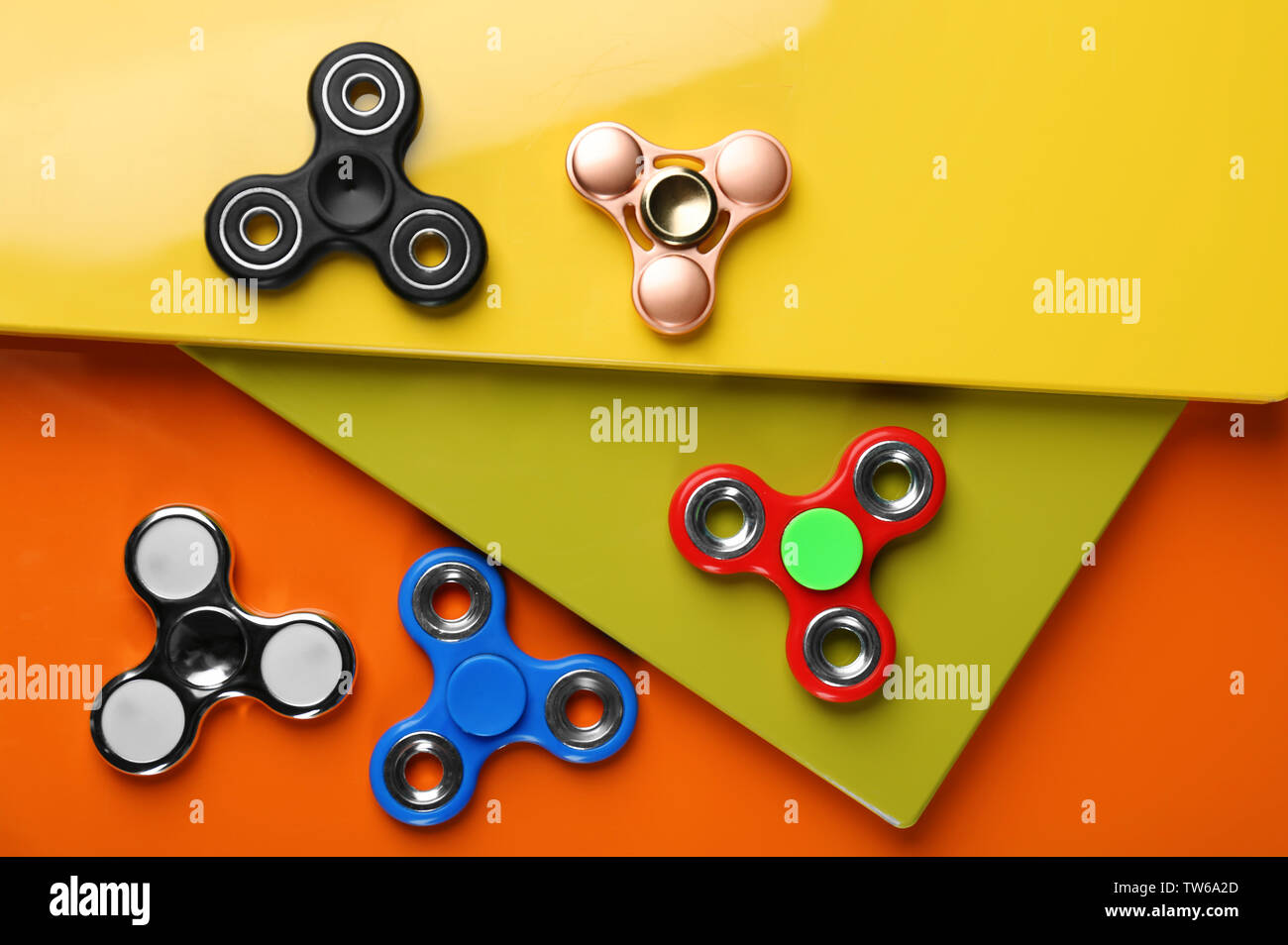 Different modern spinners on colorful background, top view Stock Photo ...