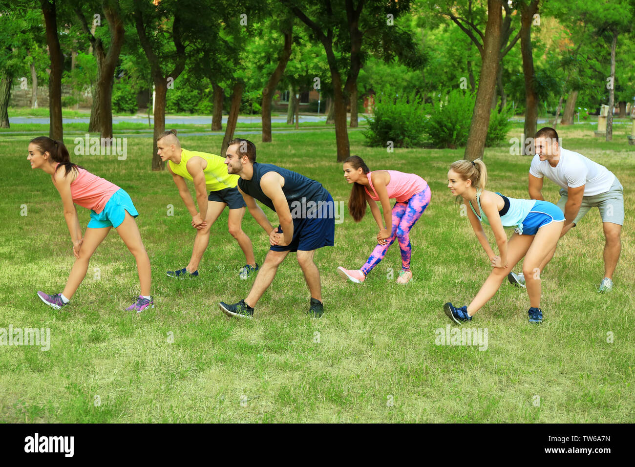 Group of young people doing exercise outdoors Stock Photo - Alamy