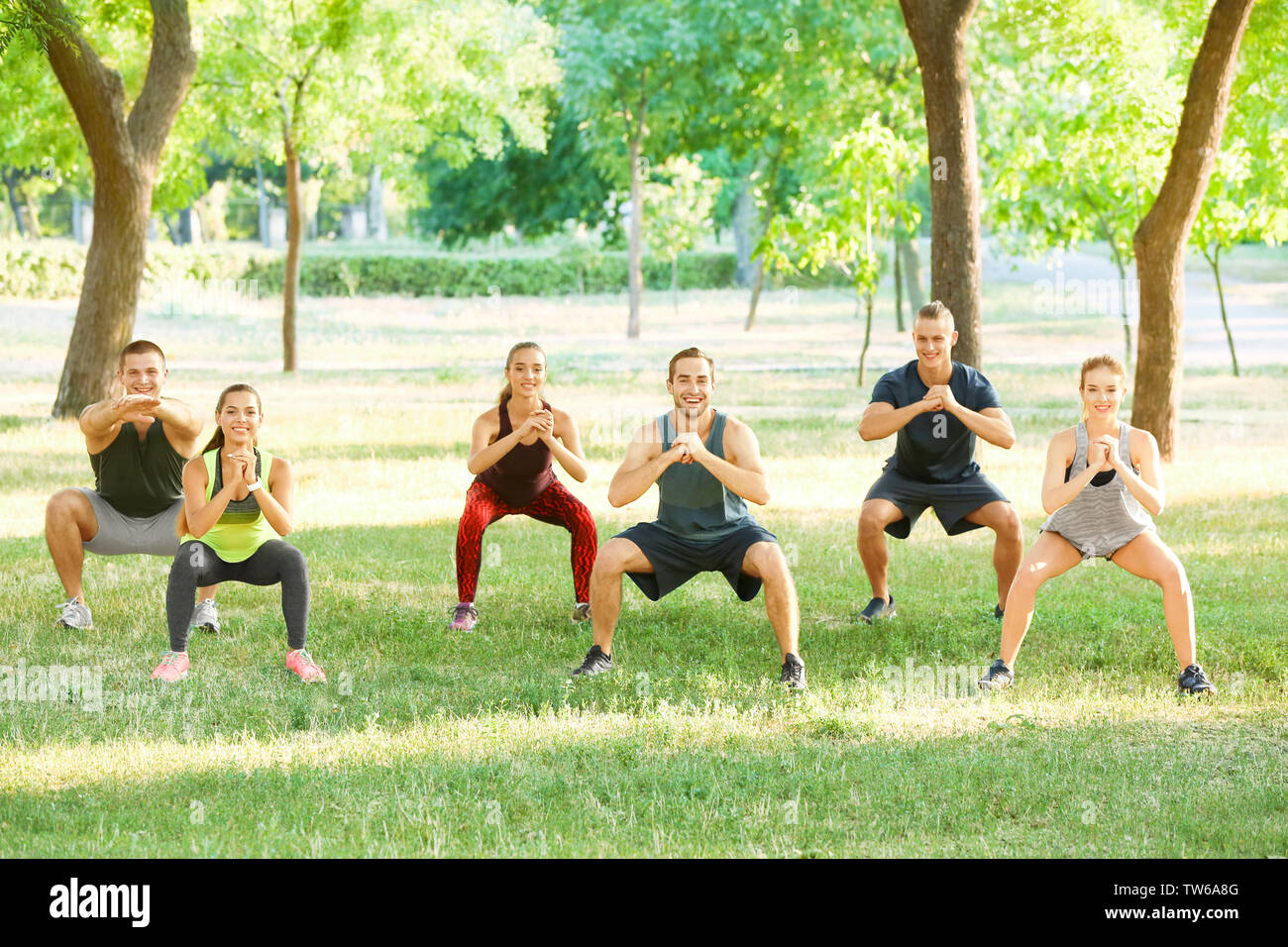 Group of young people doing exercise outdoors Stock Photo - Alamy