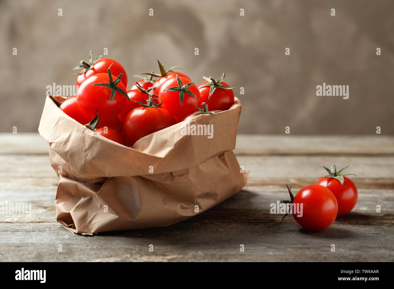 Paper bag with ripe cherry tomatoes on table Stock Photo - Alamy