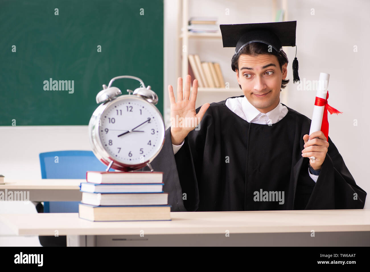 Graduate student in front of green board Stock Photo - Alamy