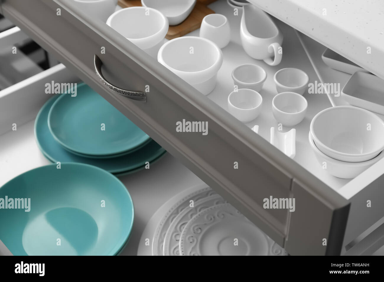 Set of ceramic tableware in kitchen drawers Stock Photo - Alamy