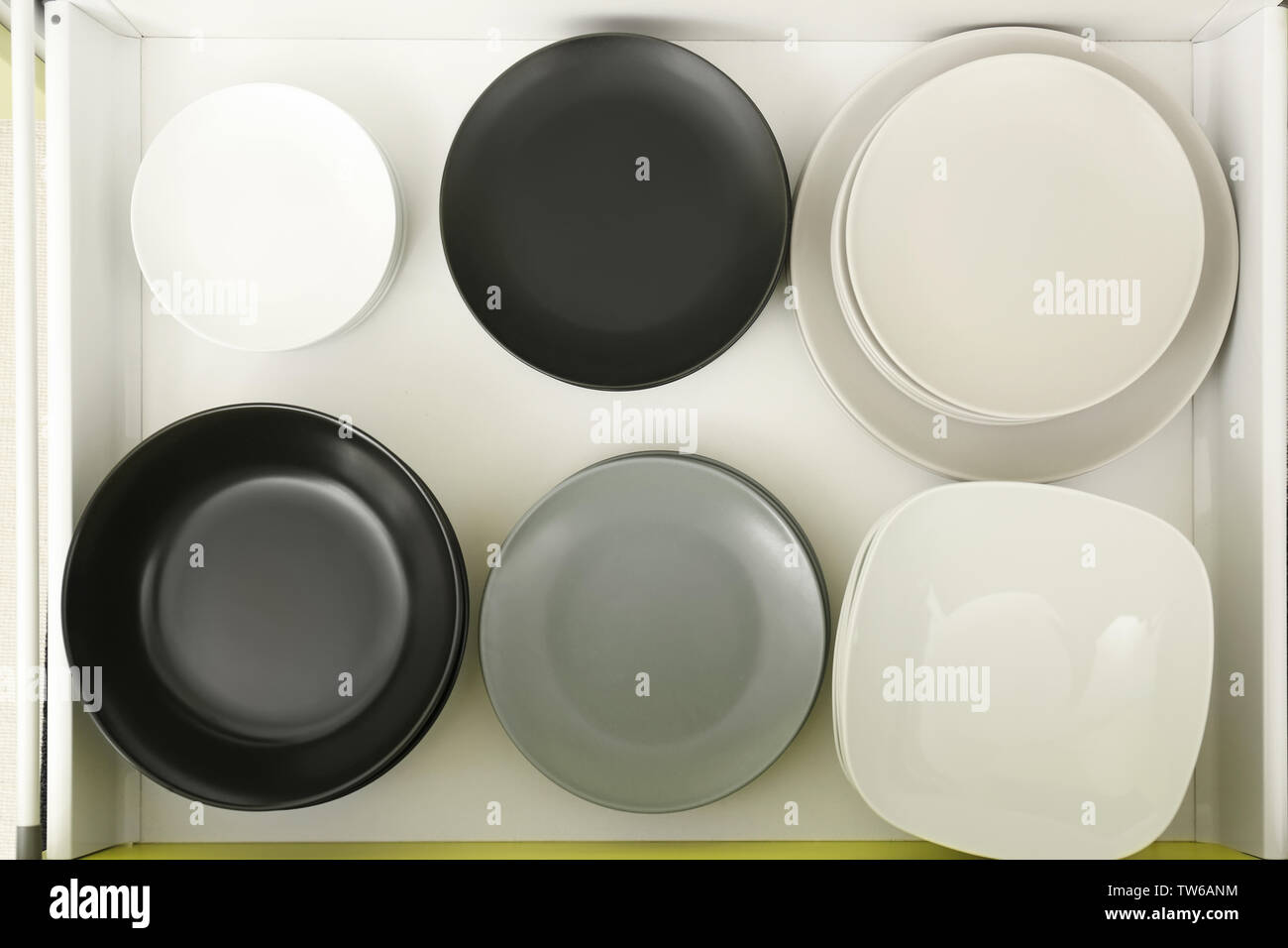Set of ceramic plates in kitchen drawer Stock Photo - Alamy