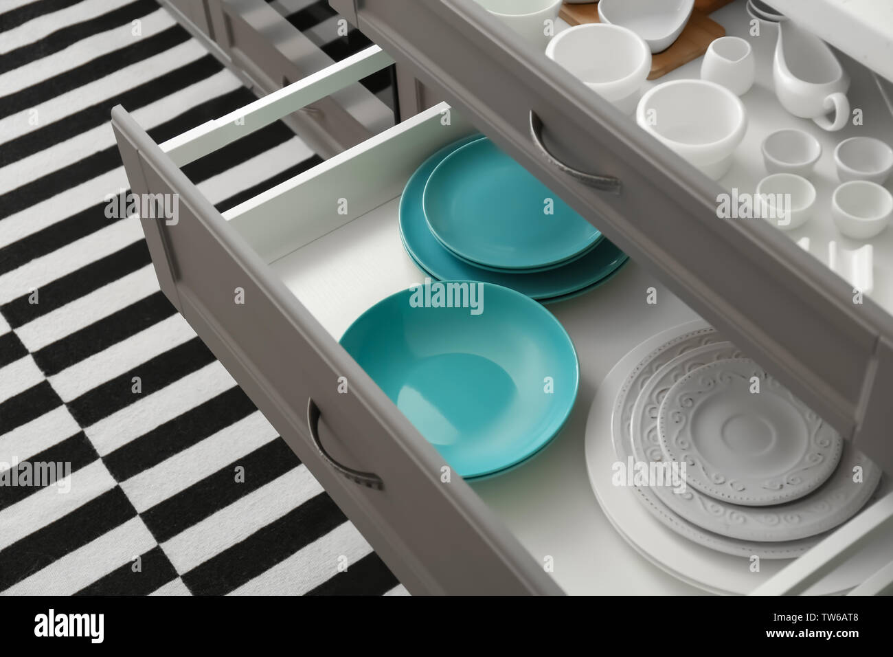 Set of ceramic tableware in kitchen drawers Stock Photo - Alamy
