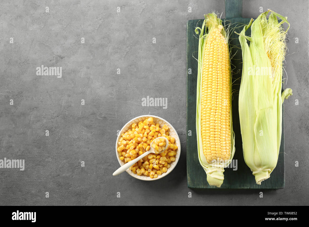 Corn kernels and cobs on grey background Stock Photo - Alamy