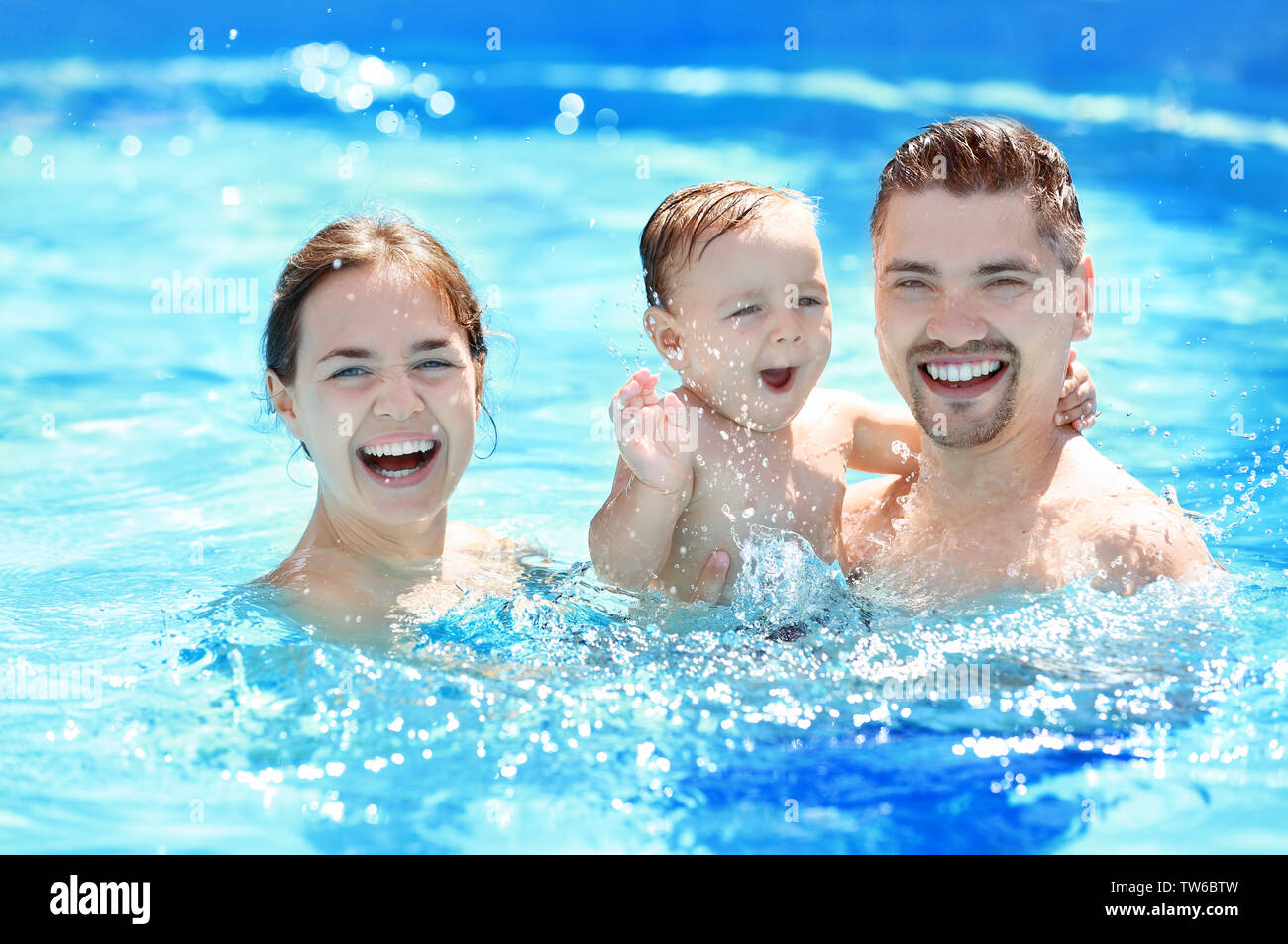 Parents and baby in swimming pool hi-res stock photography and images ...