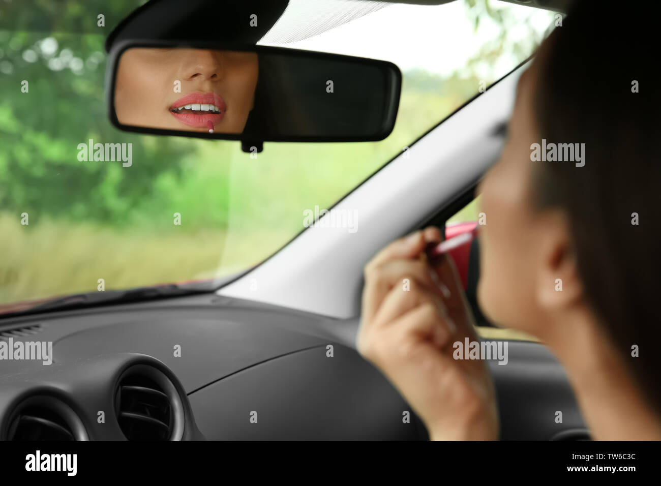 Young woman applying makeup in car Stock Photo - Alamy