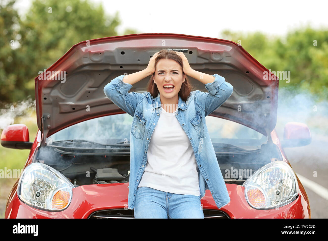 Angry young woman near broken car Stock Photo - Alamy