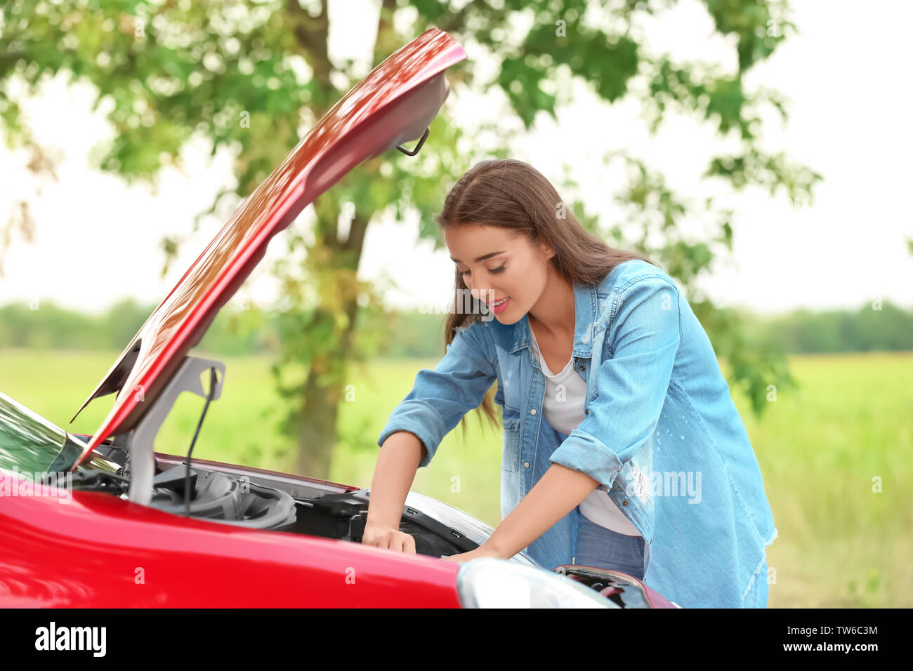 Young woman repairing car Stock Photo - Alamy