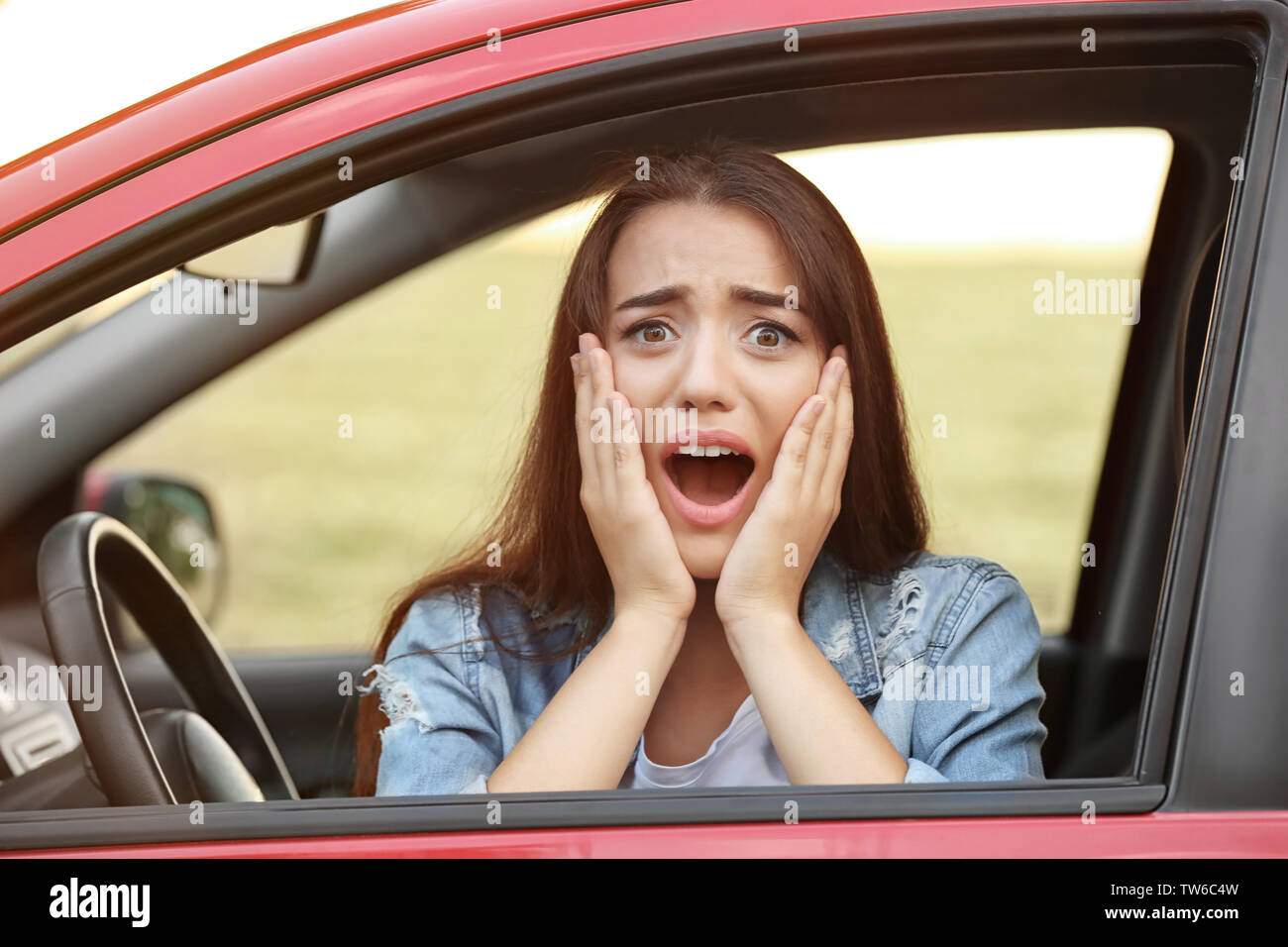Scared young woman in car Stock Photo - Alamy