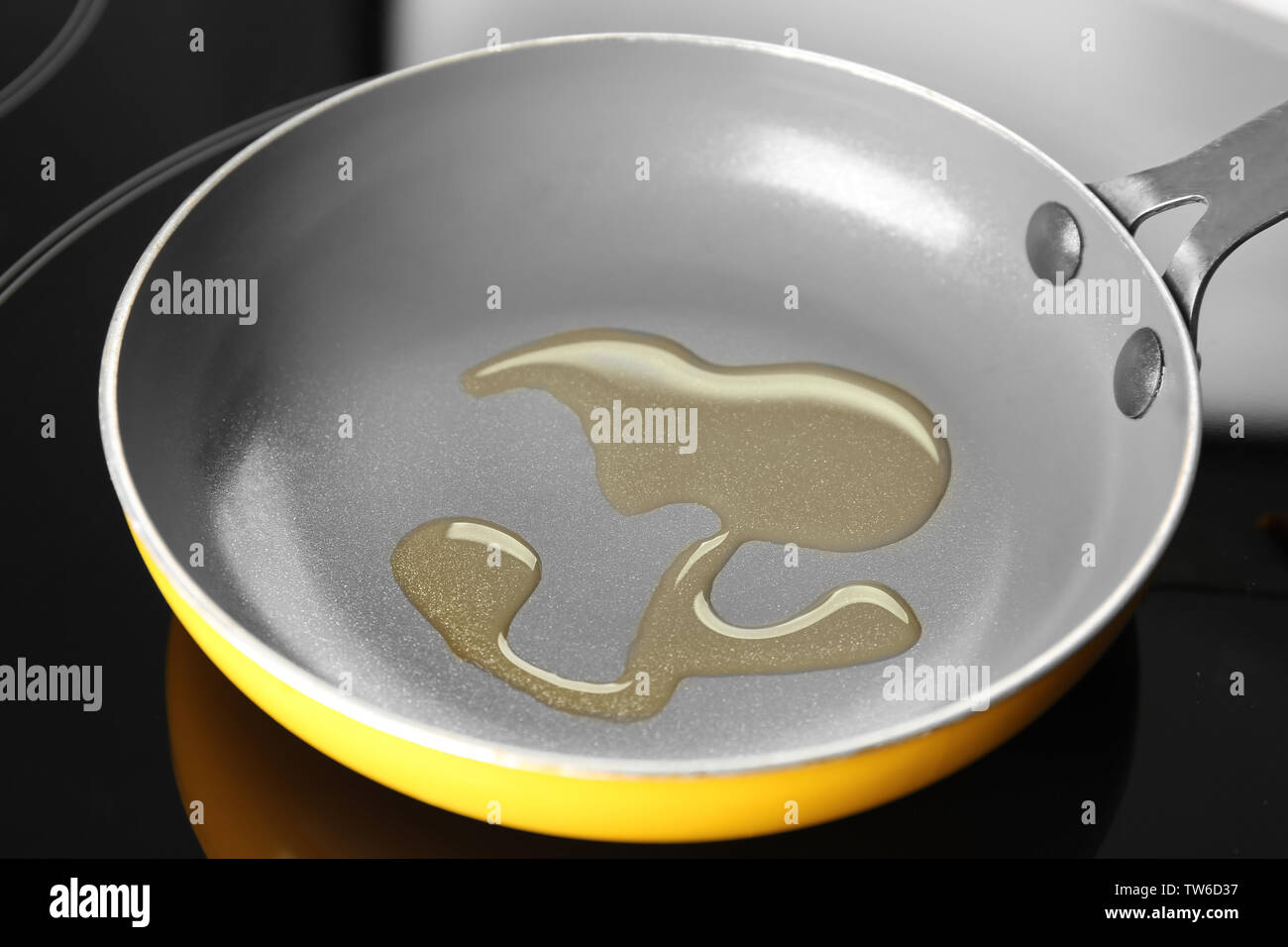 Frying pan with cooking oil on electric cooker Stock Photo - Alamy