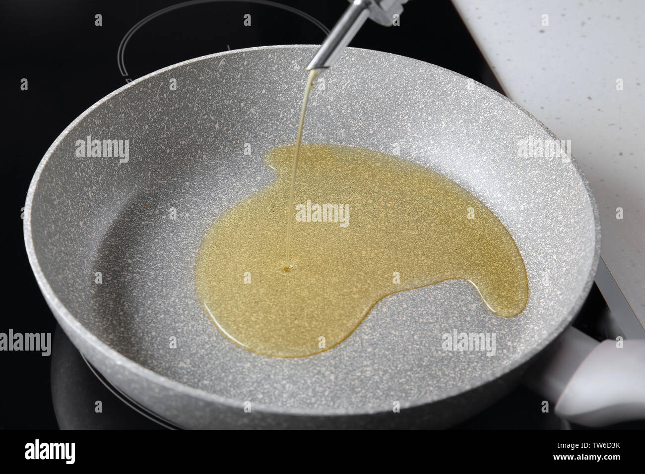 Frying pan with cooking oil on electric cooker Stock Photo - Alamy