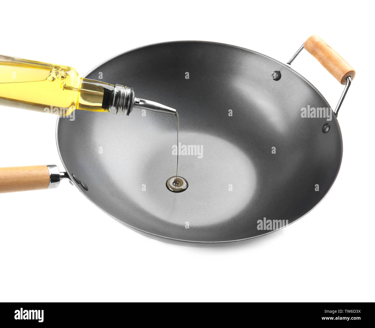 Pouring oil into frying pan on white background Stock Photo - Alamy