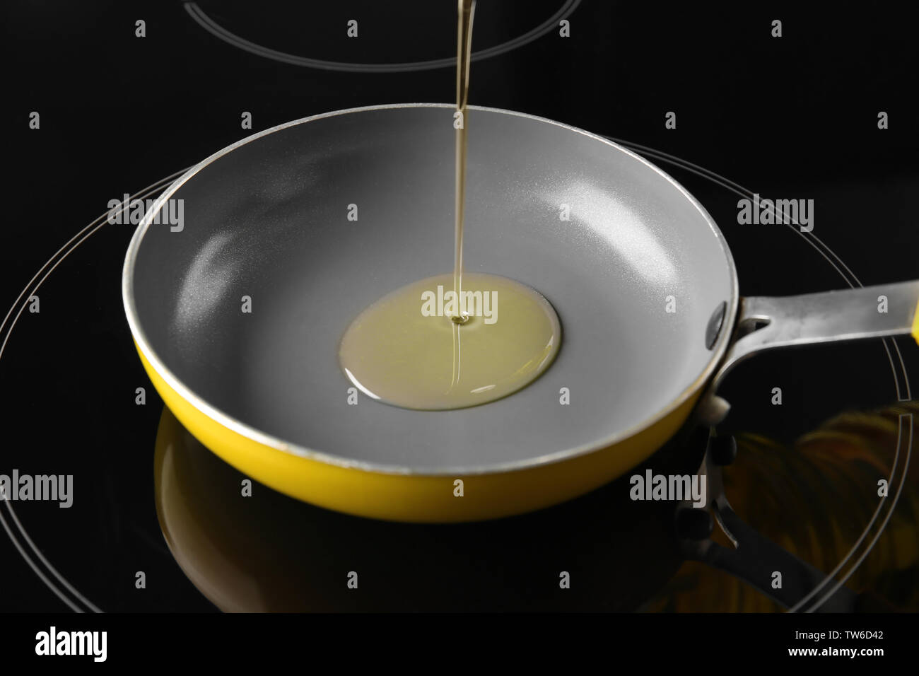 Pouring oil into frying pan, closeup Stock Photo - Alamy
