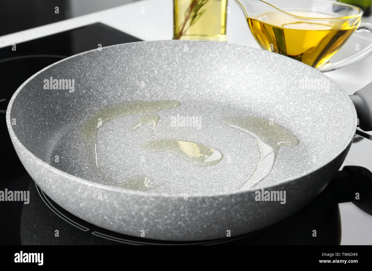 Frying pan with cooking oil on electric cooker Stock Photo - Alamy