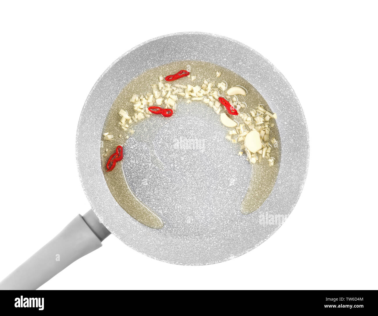 Frying pan with cooking oil, chopped garlic and chili on white ...