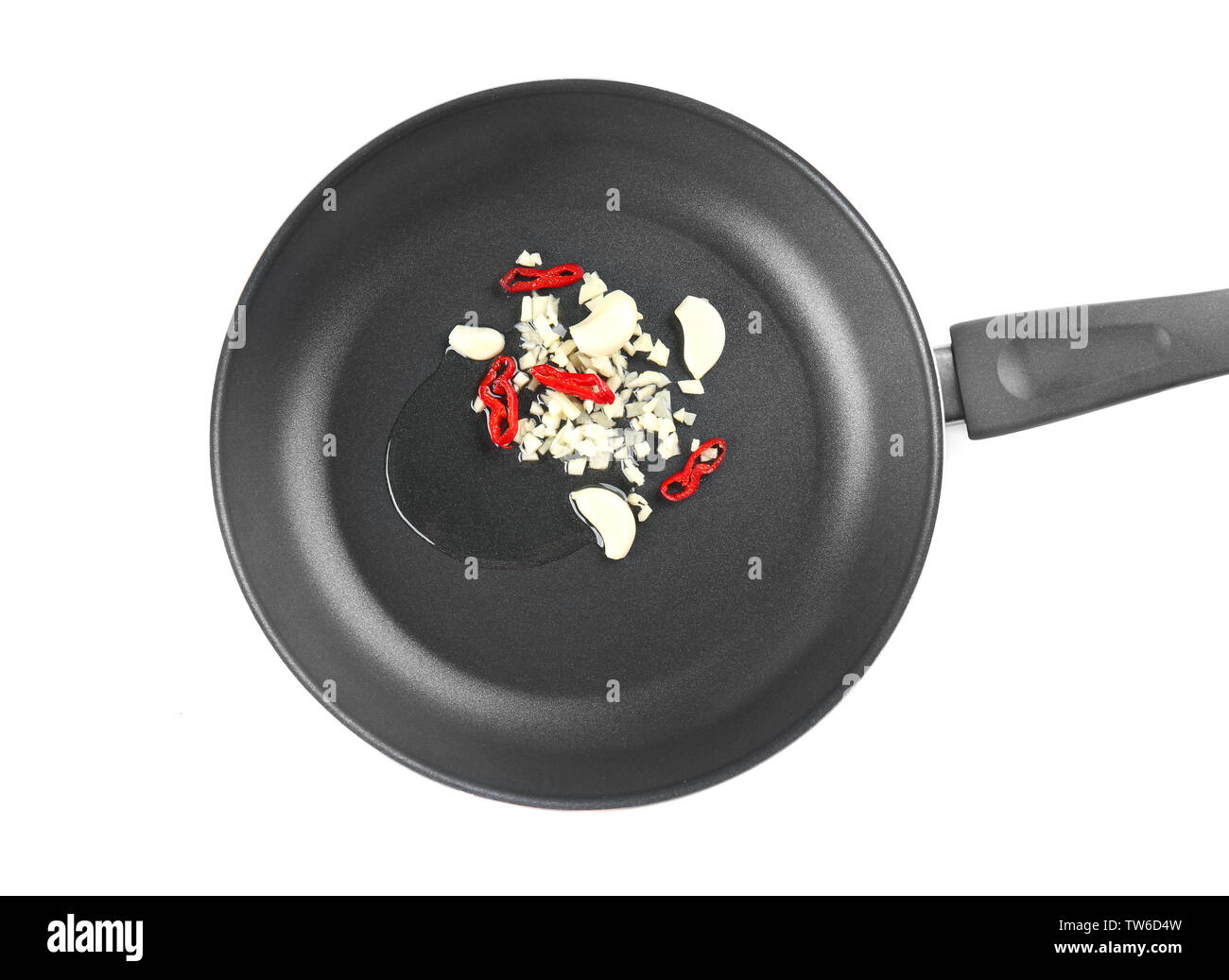Frying pan with cooking oil, chopped garlic and chili on white ...