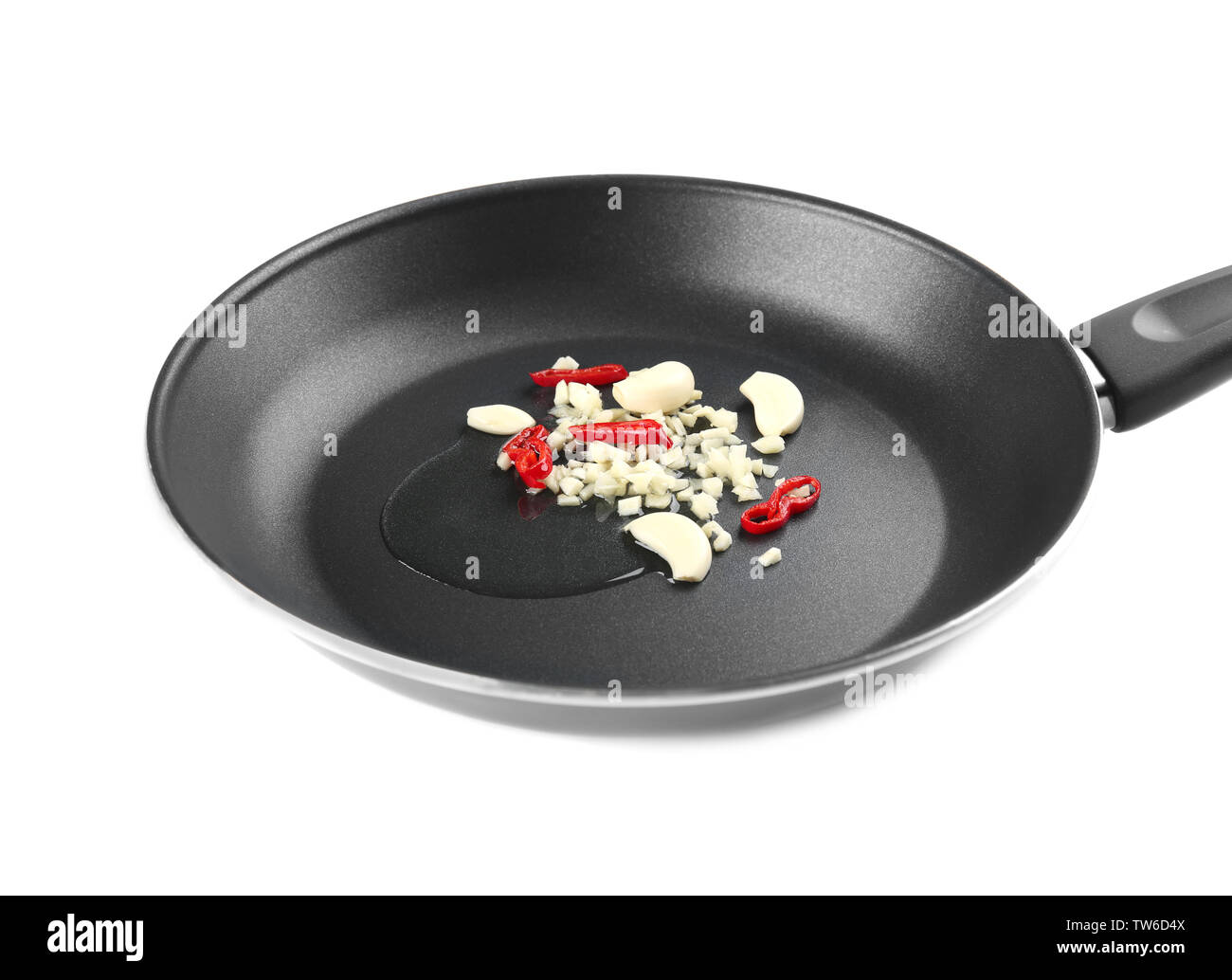 Frying pan with cooking oil, chopped garlic and chili on white ...