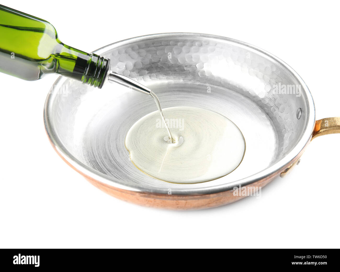 Pouring oil into frying pan on white background Stock Photo - Alamy