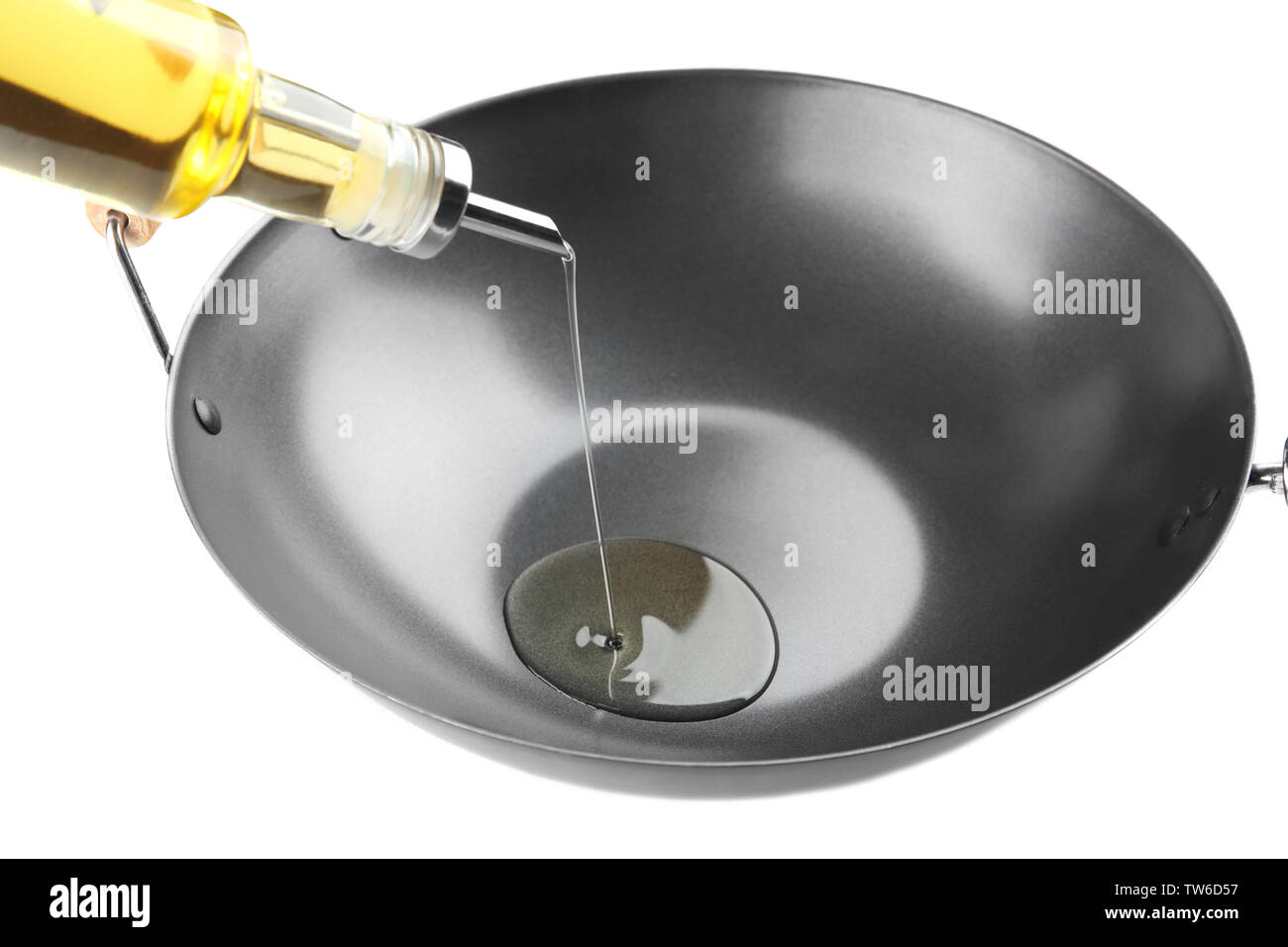 Pouring oil into frying pan on white background Stock Photo - Alamy