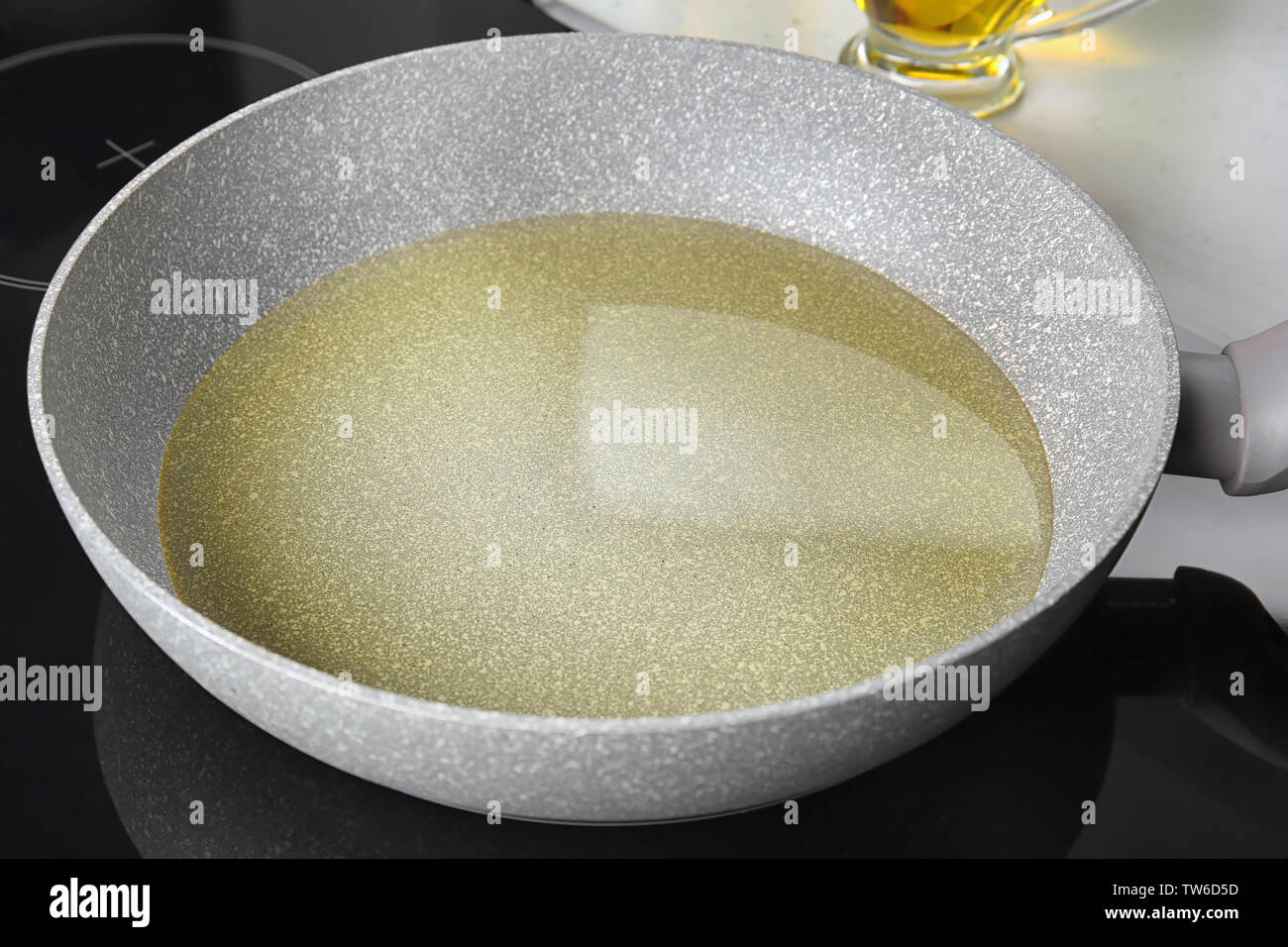 Frying pan with cooking oil on electric cooker Stock Photo - Alamy