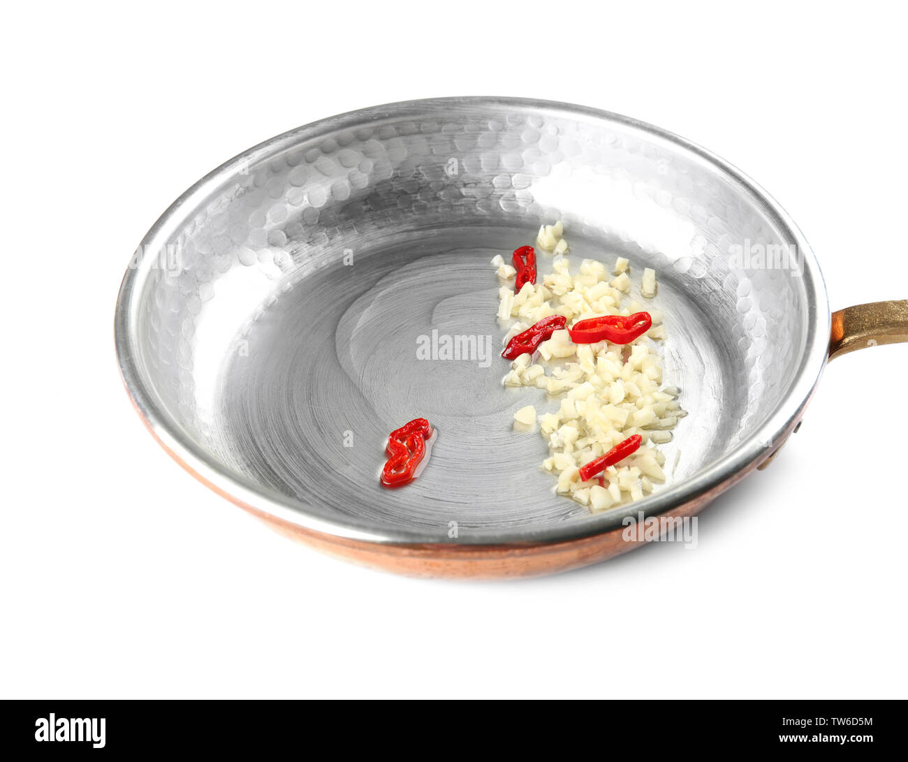 Frying pan with cooking oil, chopped garlic and chili on white ...