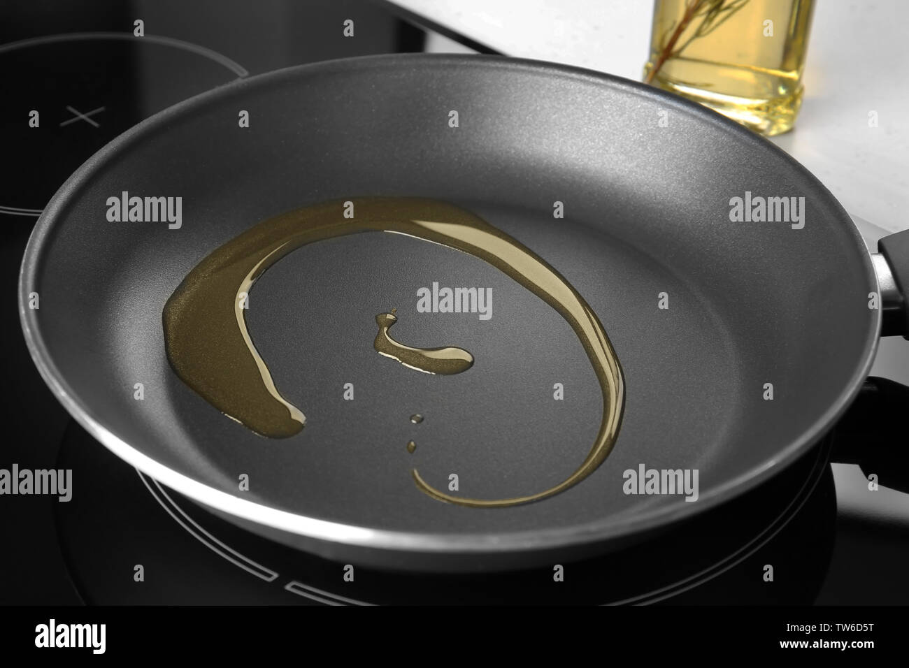 Frying pan with cooking oil on electric cooker Stock Photo - Alamy