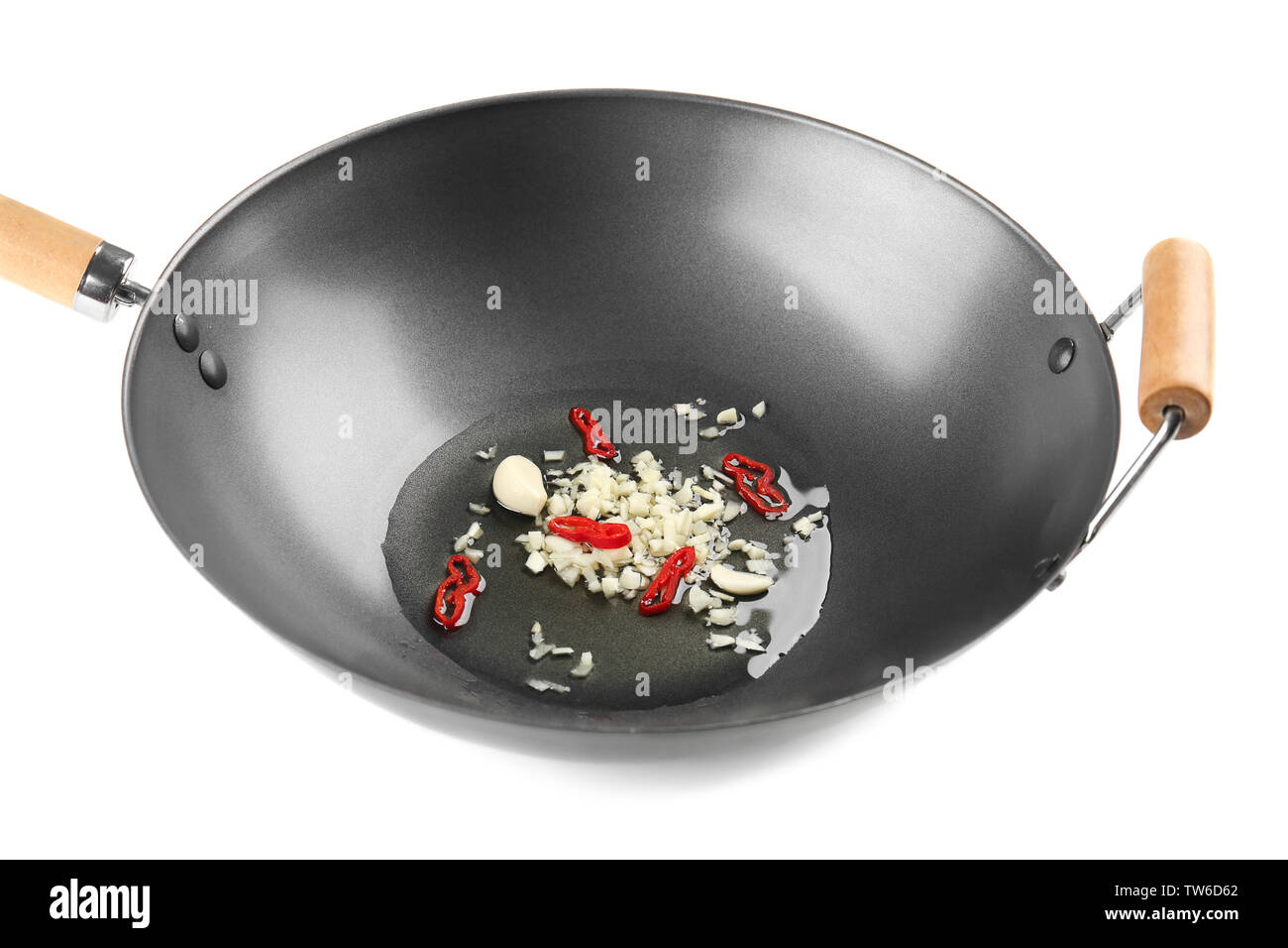 Frying pan with cooking oil, chopped garlic and chili on white ...
