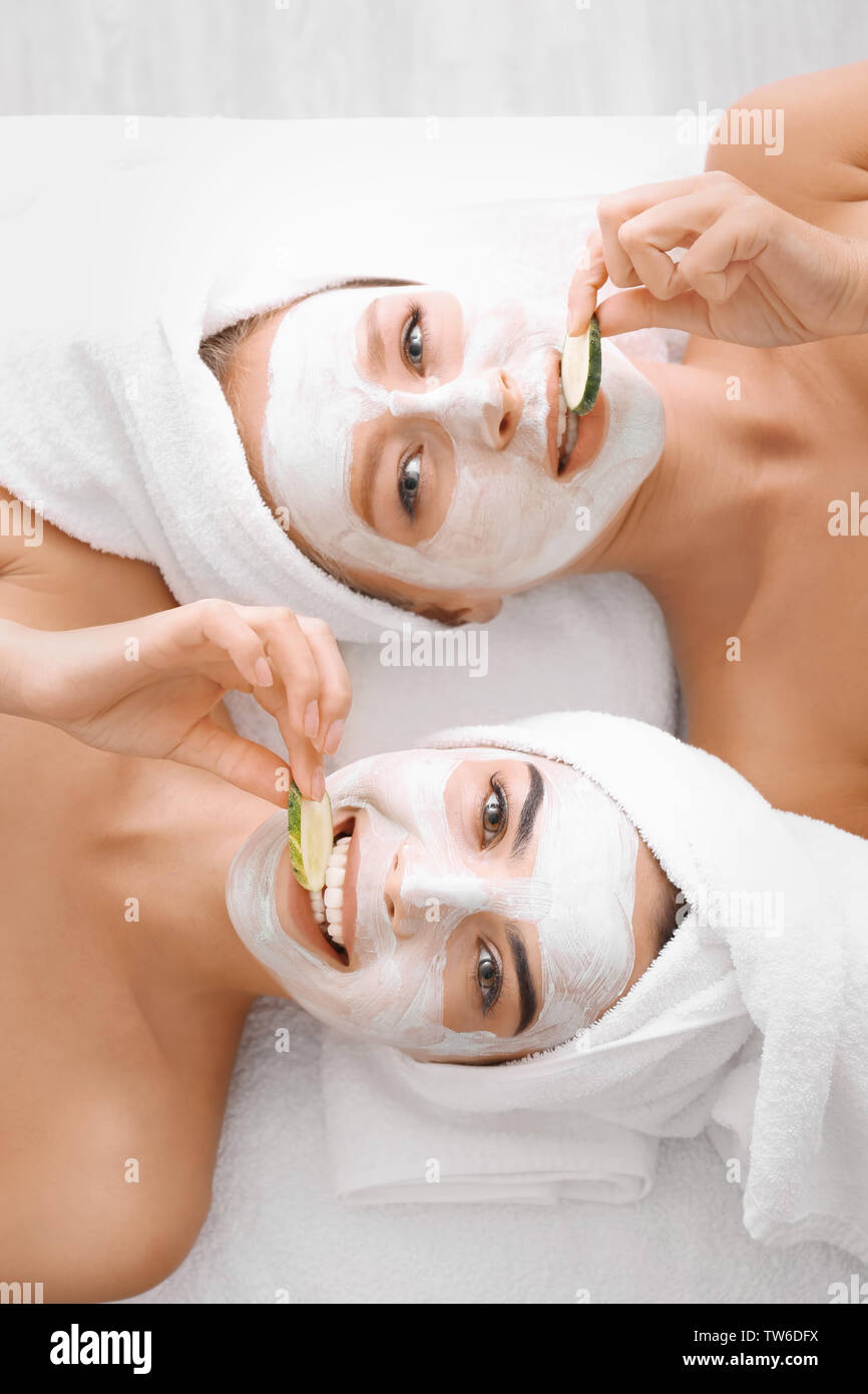 Young women with facial masks and cucumber slices in spa salon Stock ...