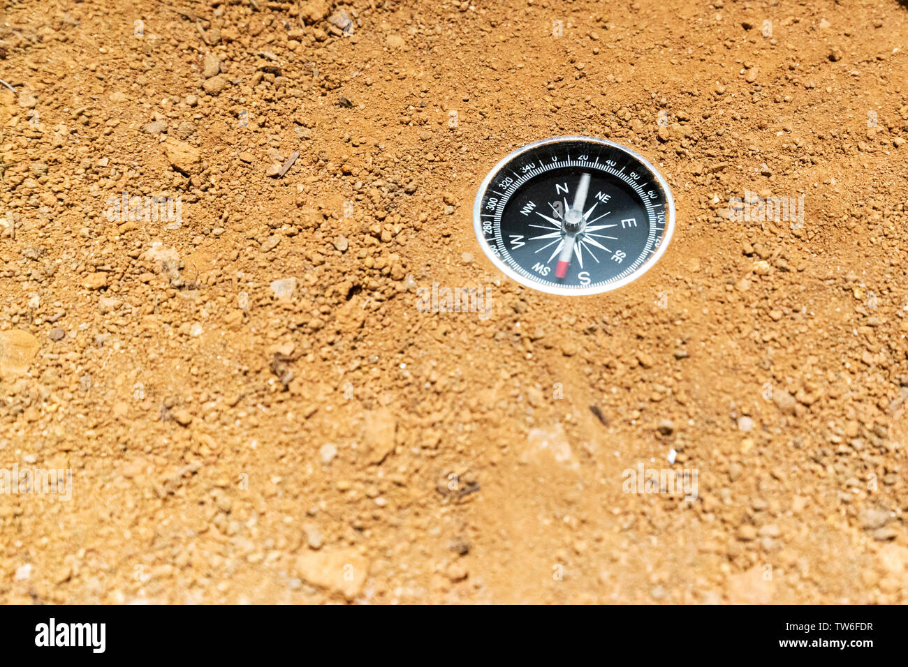 Compass in brown earth Stock Photo - Alamy