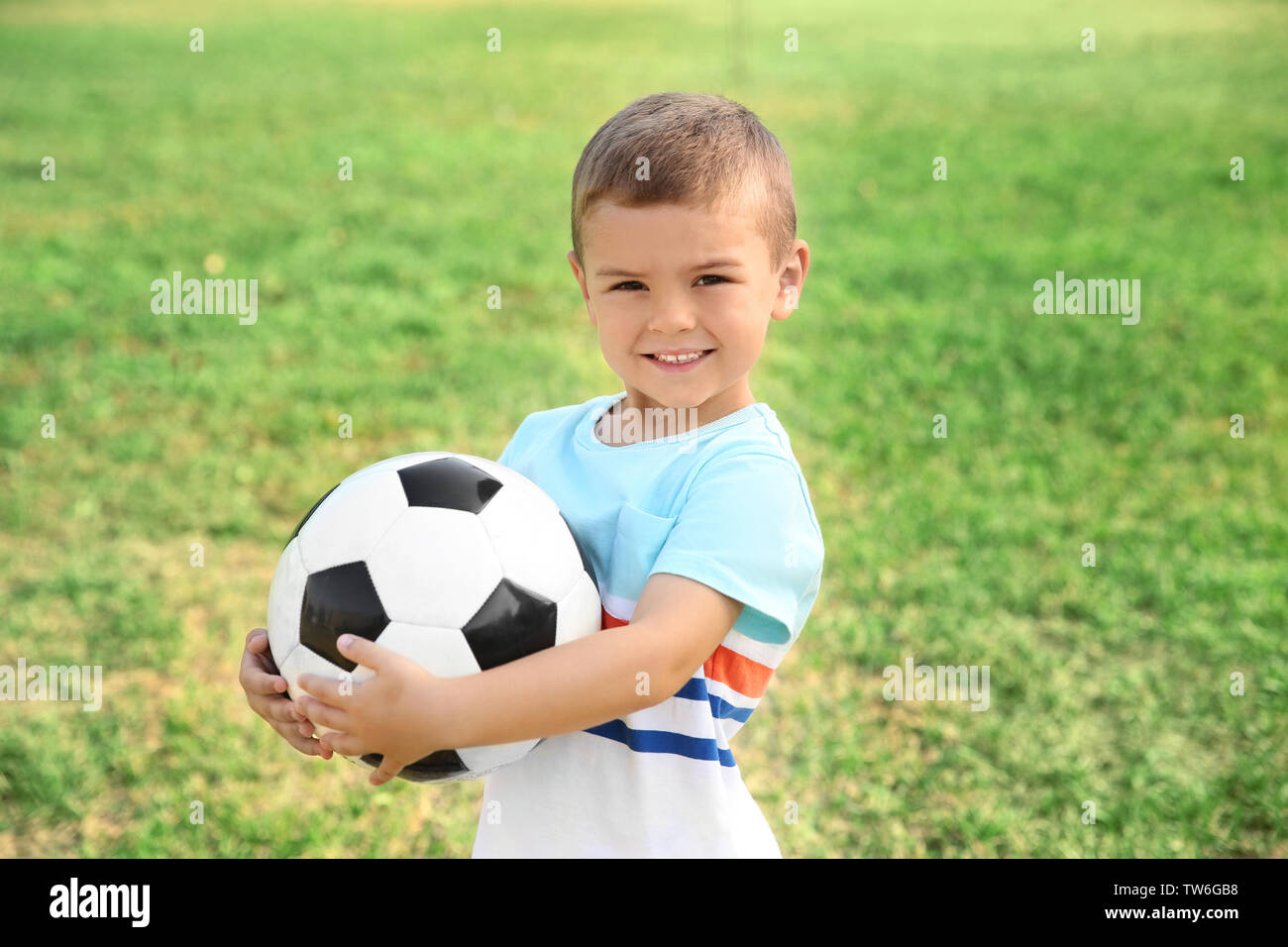 Cute little boy holding ball outdoors Stock Photo - Alamy