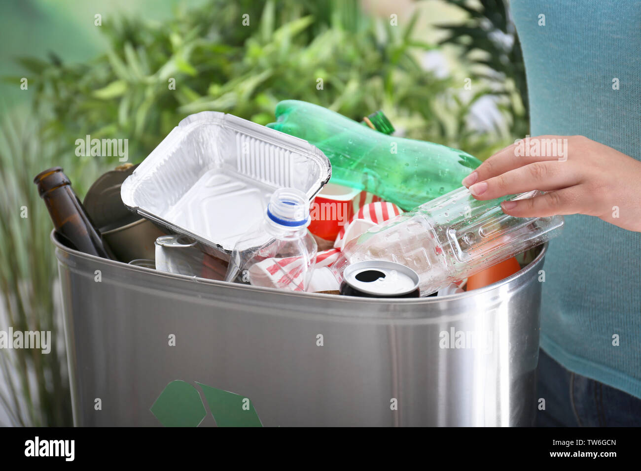 Young woman throwing plastic bottle into litter bin, close up Stock ...