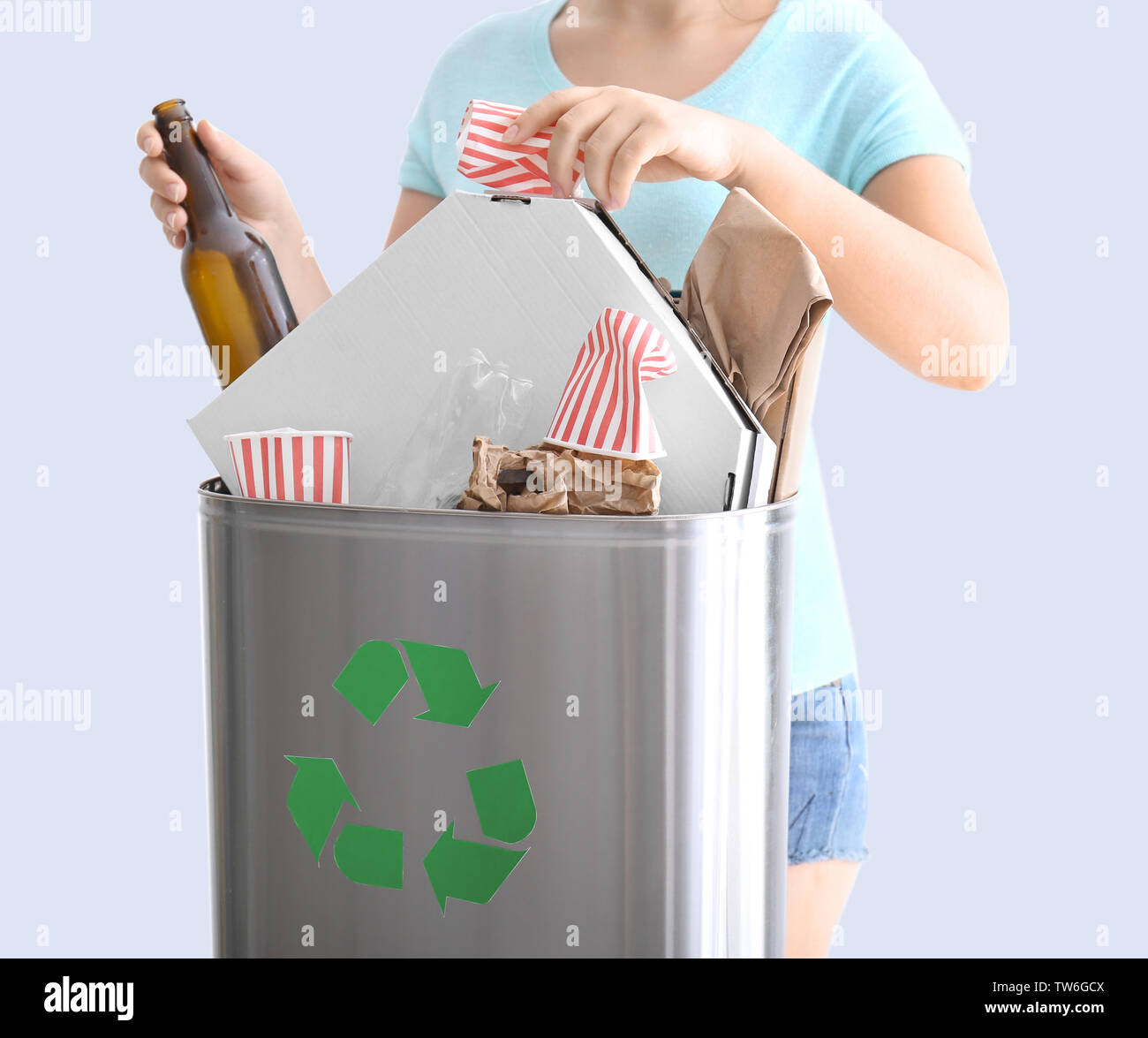 Young woman throwing garbage into litter bin on white background Stock ...