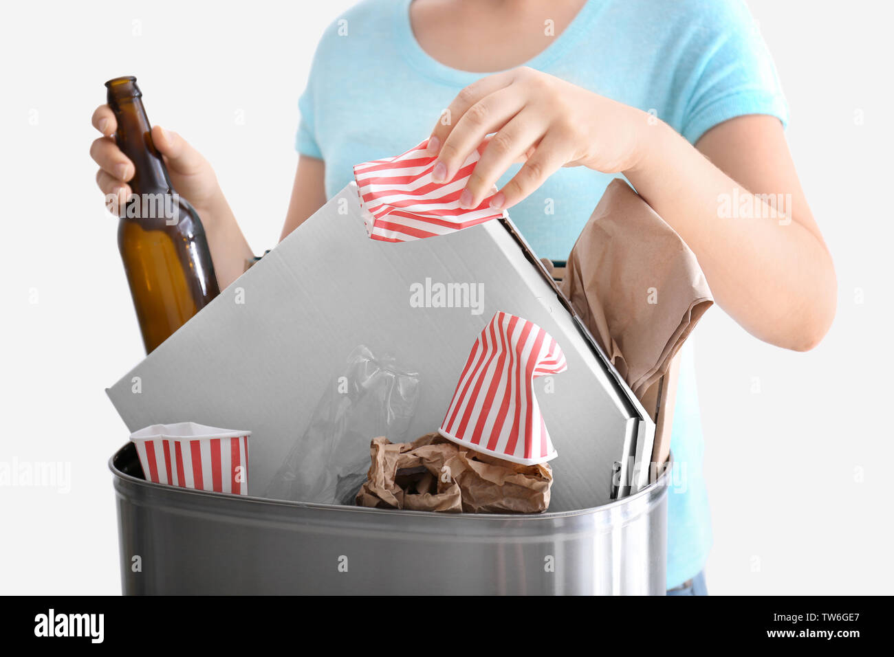 Young woman throwing garbage into litter bin on white background Stock ...