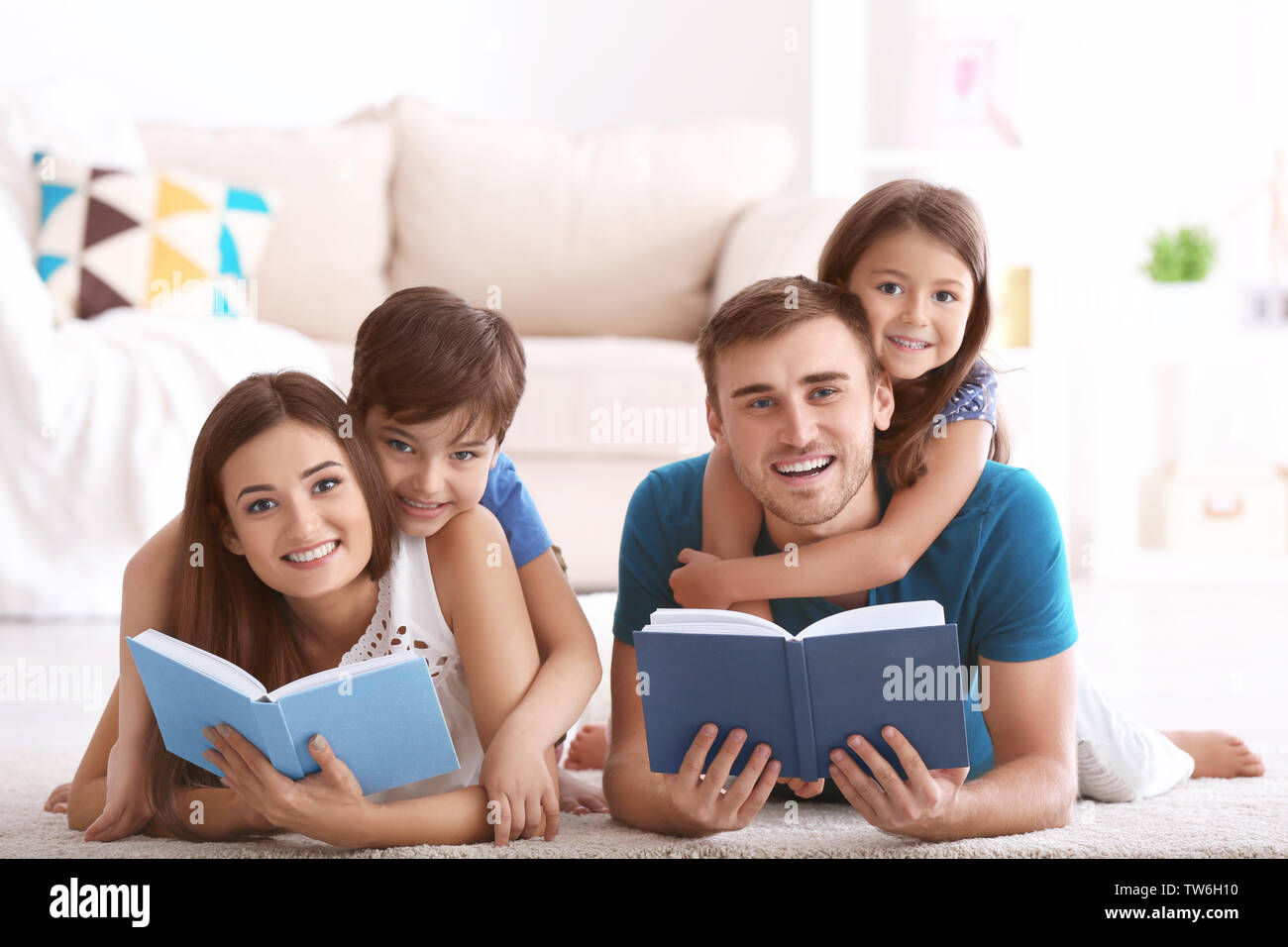 Happy family reading books at home Stock Photo - Alamy