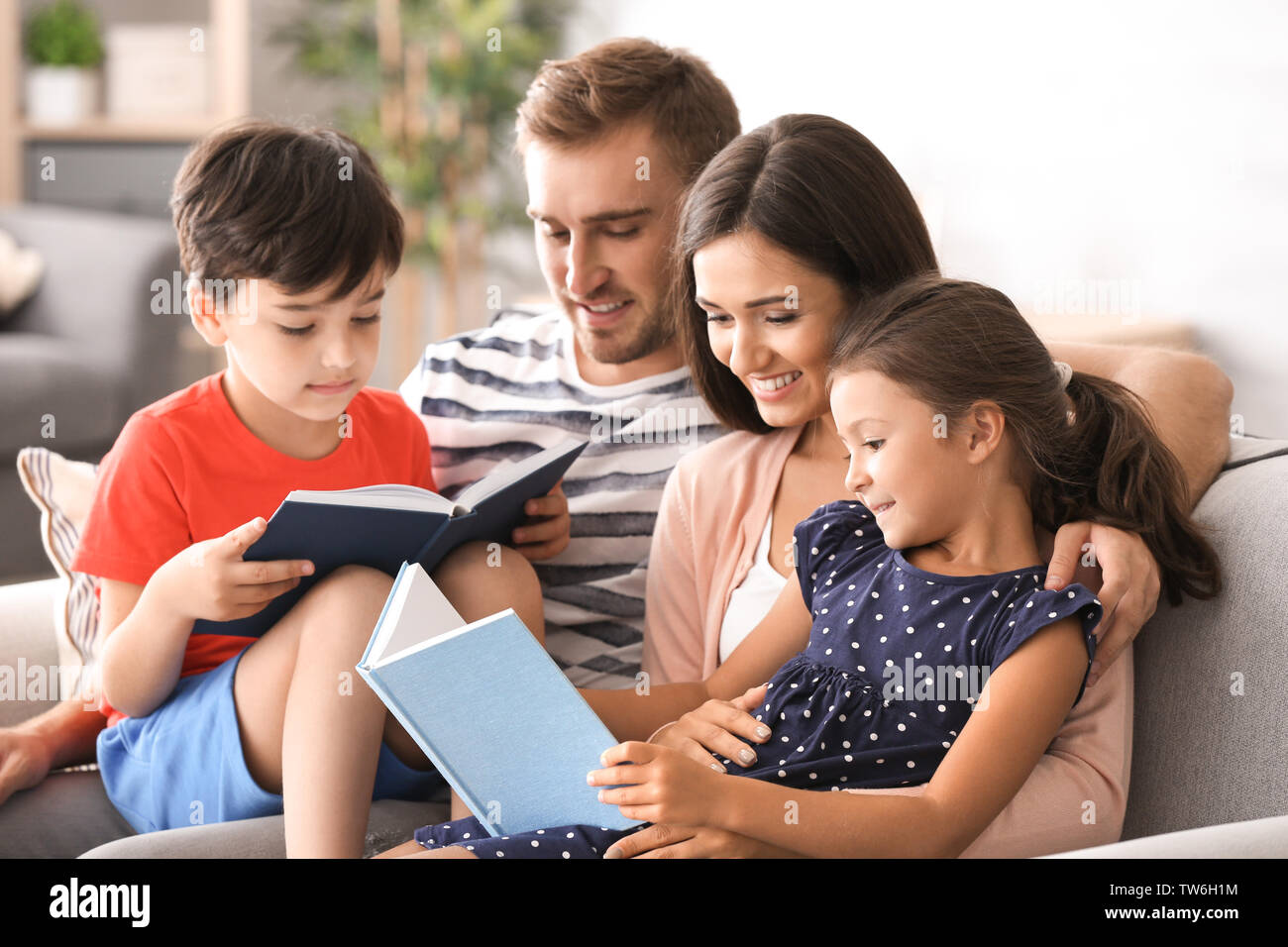 Happy family reading books at home Stock Photo - Alamy