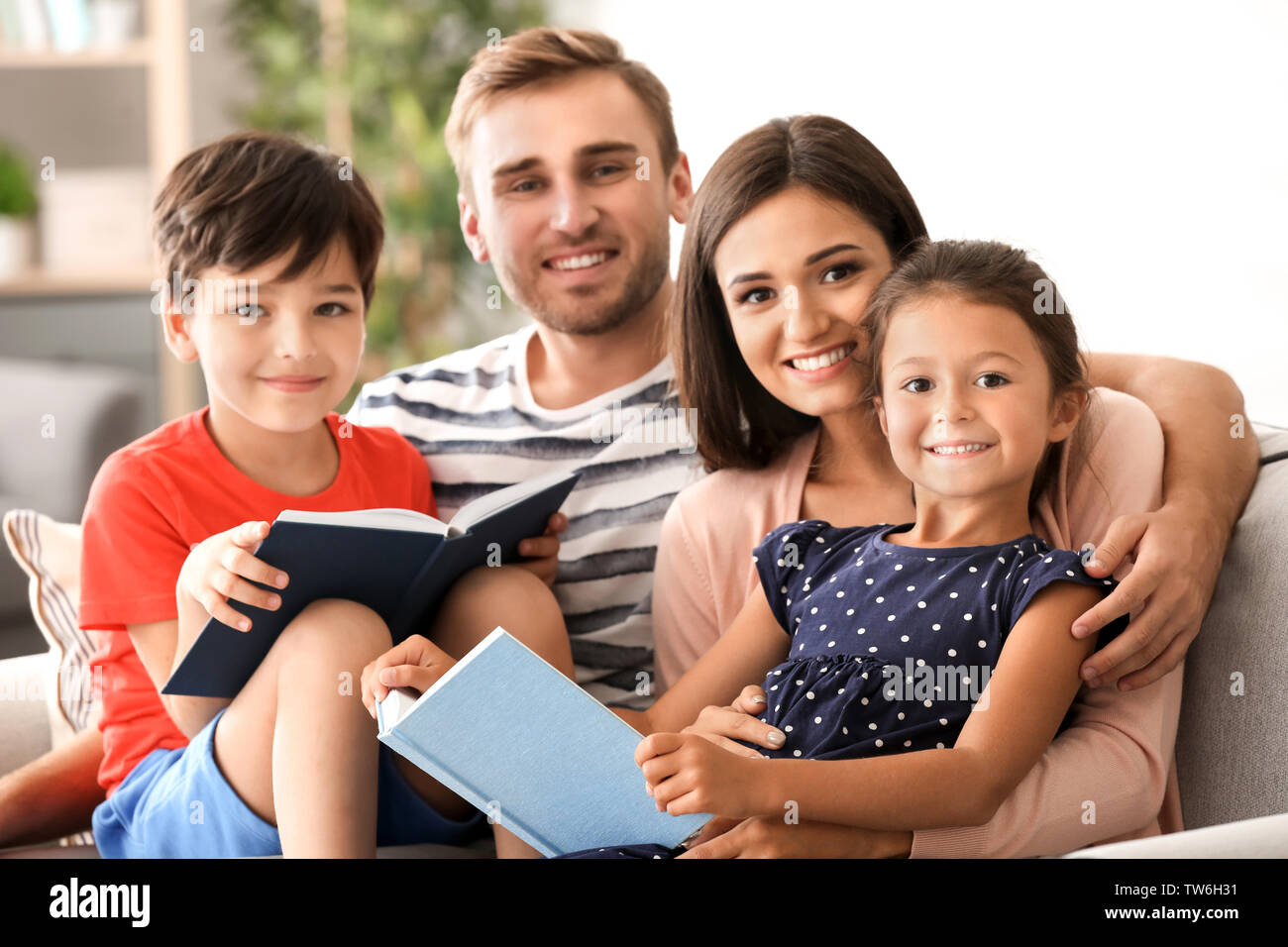Happy family reading books at home Stock Photo - Alamy