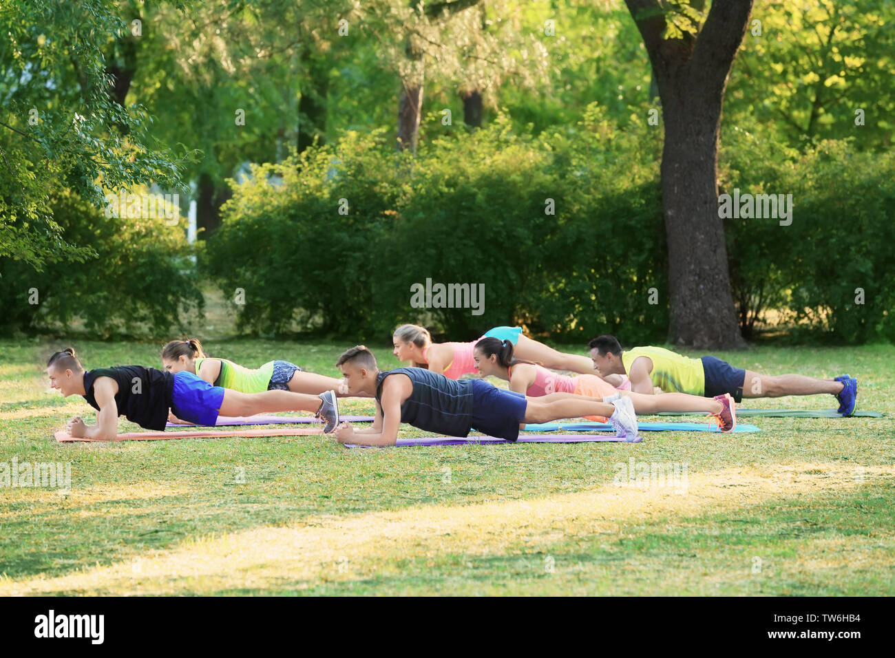 Group of young people doing exercise outdoor Stock Photo - Alamy