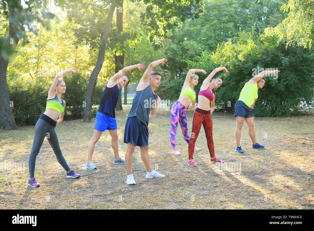 Group of young people doing exercise outdoor Stock Photo - Alamy