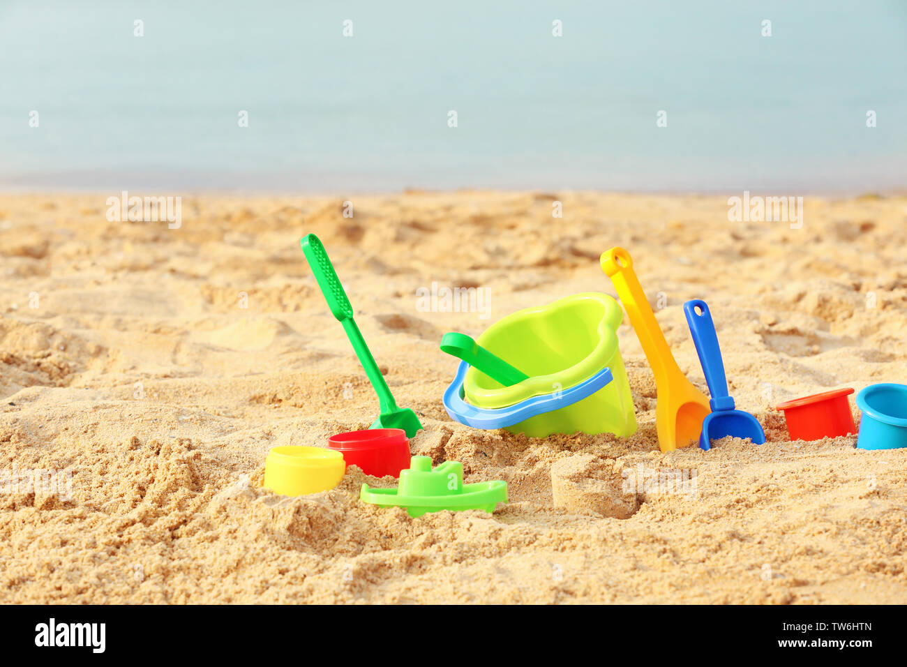 Children's beach toys on sand Stock Photo - Alamy